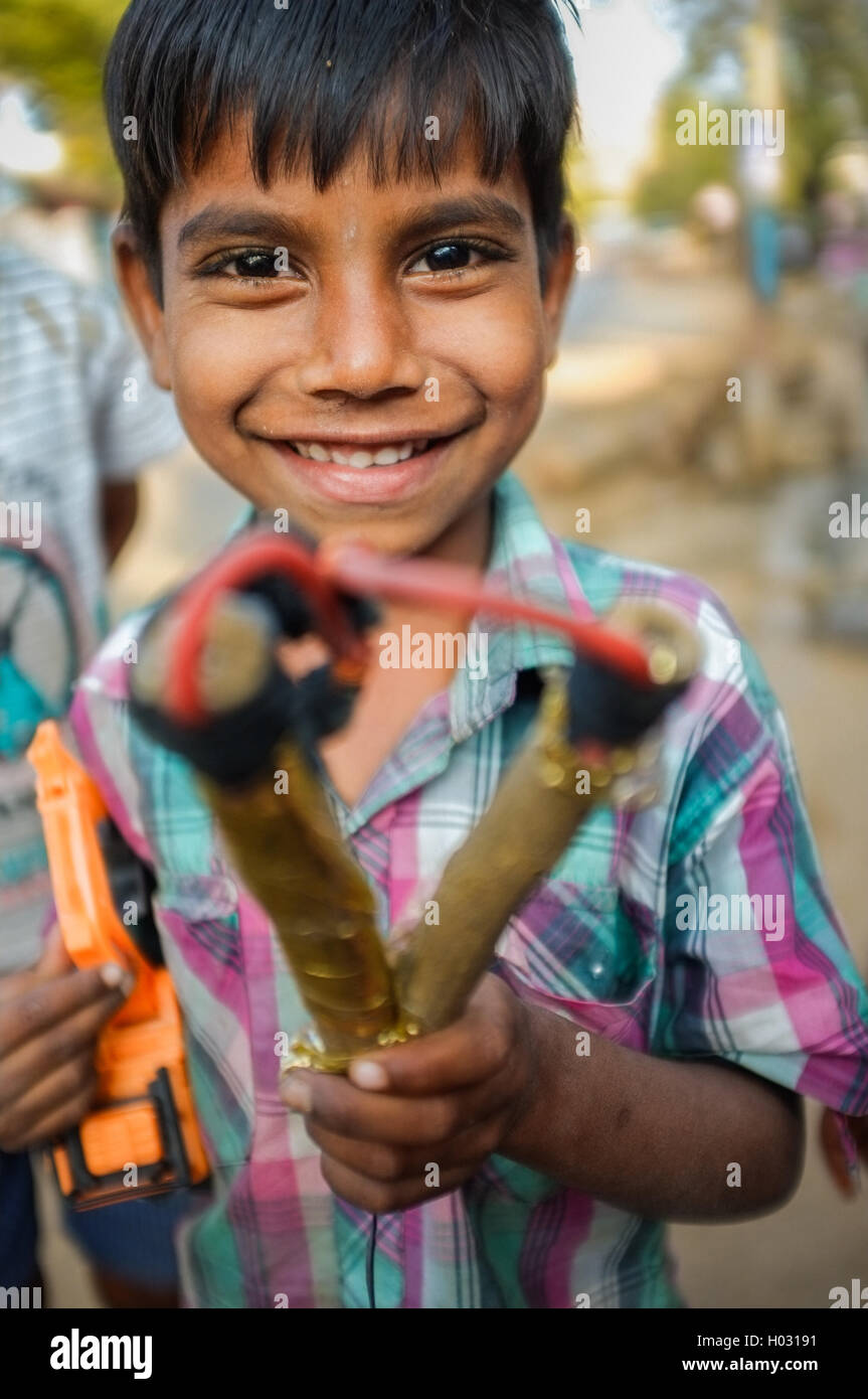 HAMPI, INDIA - 31 JANUARY 2015: Indian boy holding slingshot and toy ...