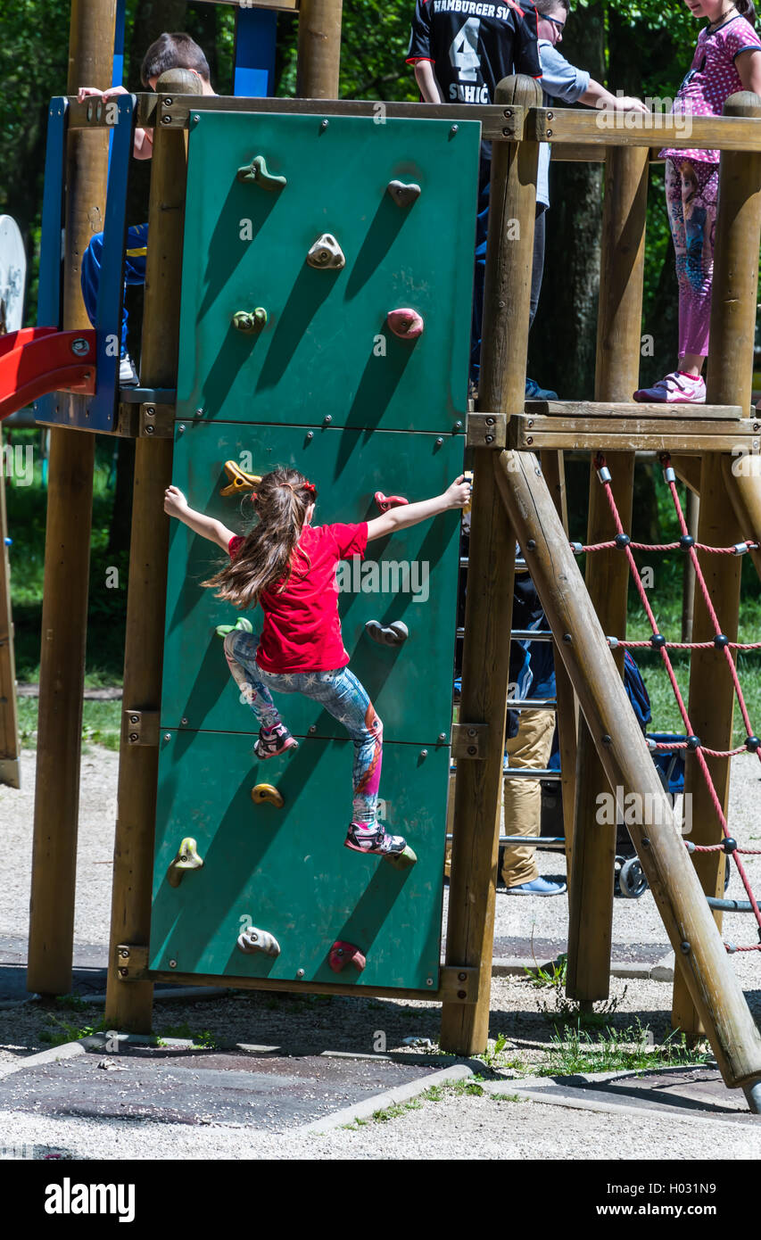 A girl climbs on the children climbing wall at the park Stock Photo - Alamy