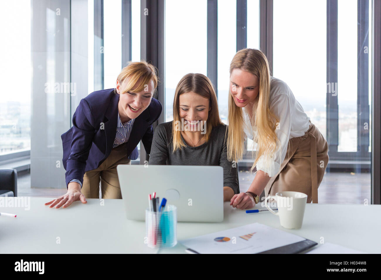 Three business women in modern office working on the project together ...