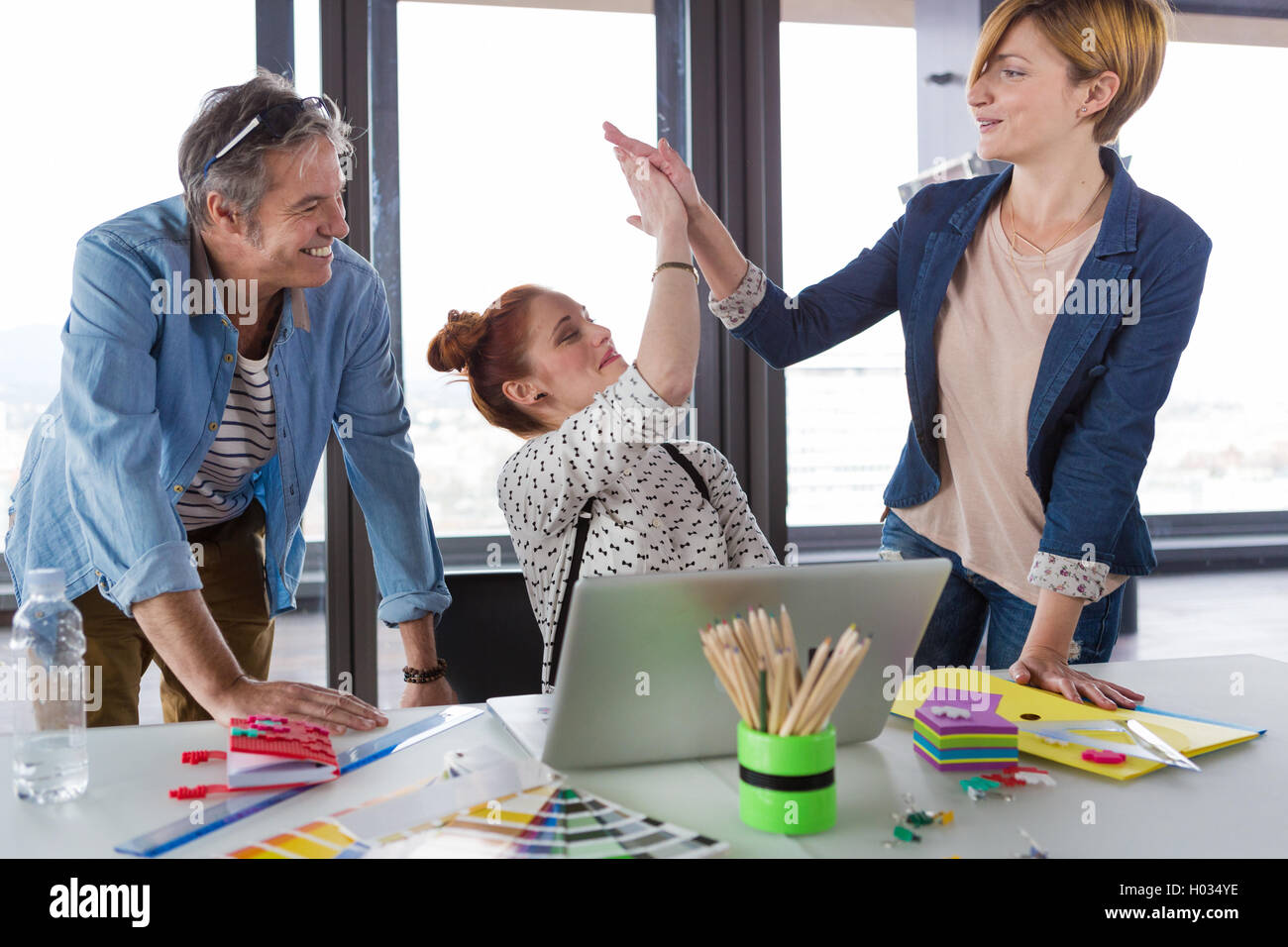 Business people in modern office celebrating good business results ...