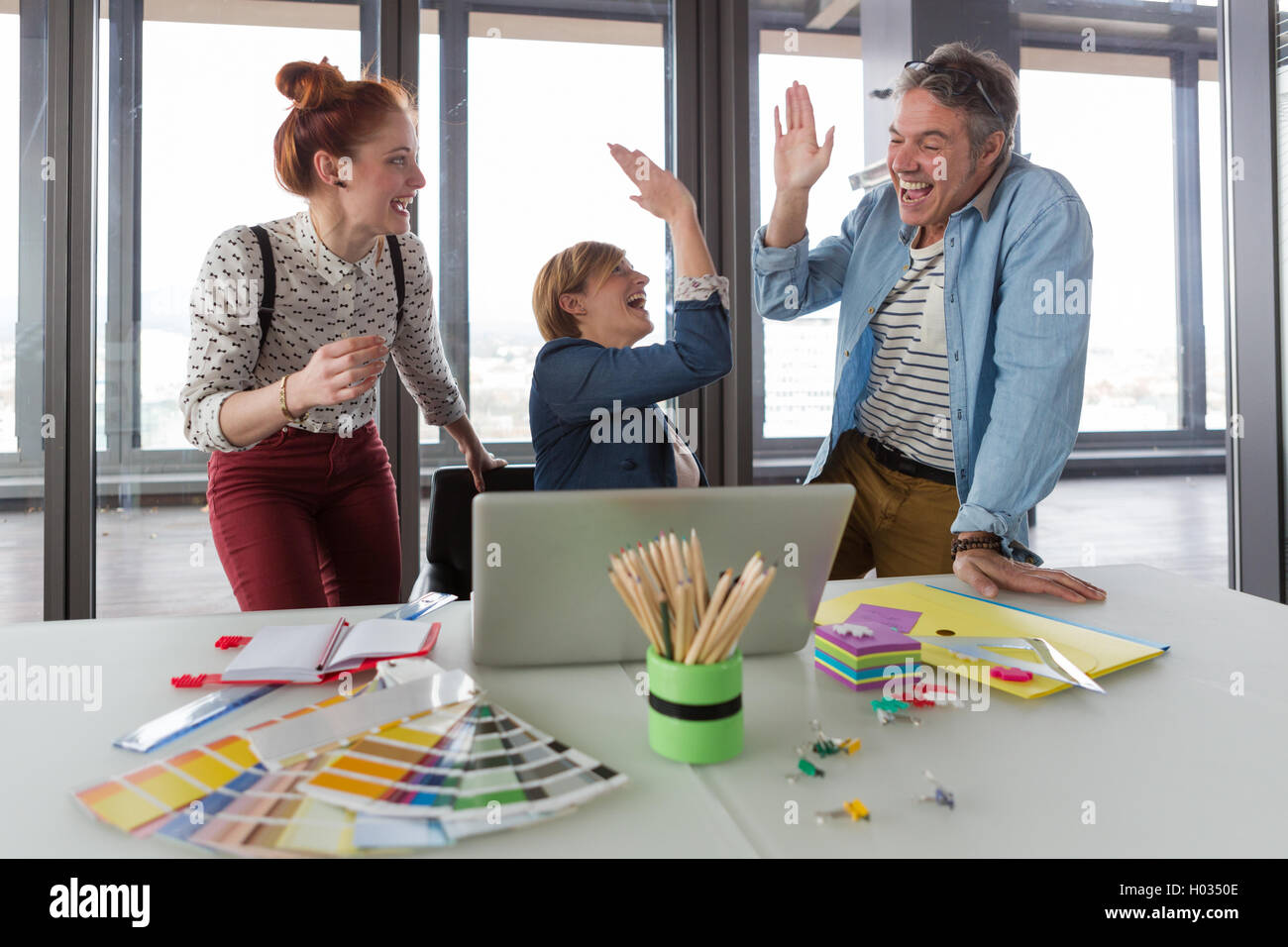 Business people in modern office celebrating good business results ...