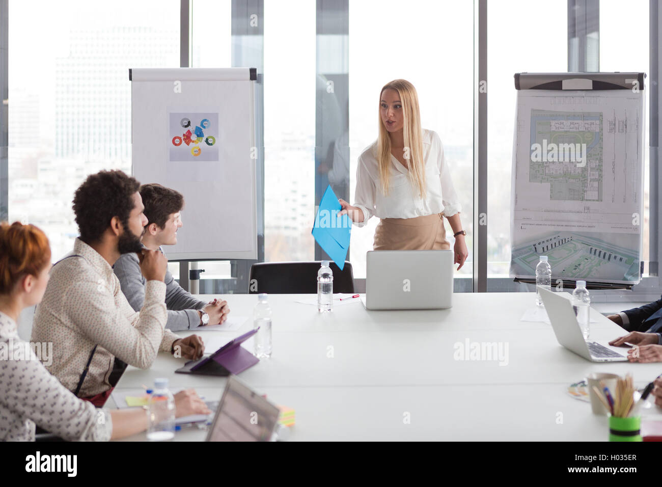 Business woman presenting project to her colleagues in modern office ...
