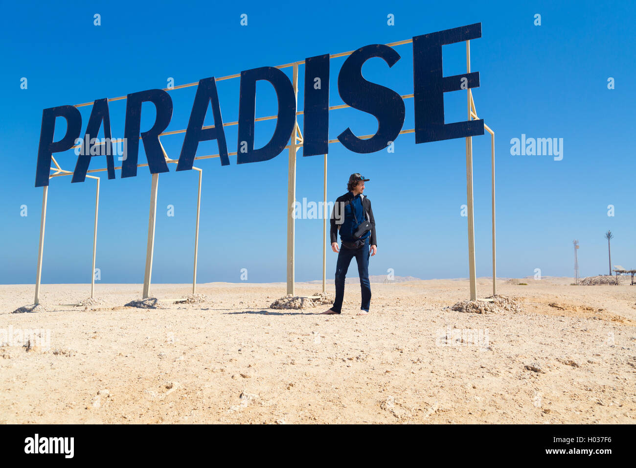 Tourist standing under the Paradise sign Stock Photo - Alamy