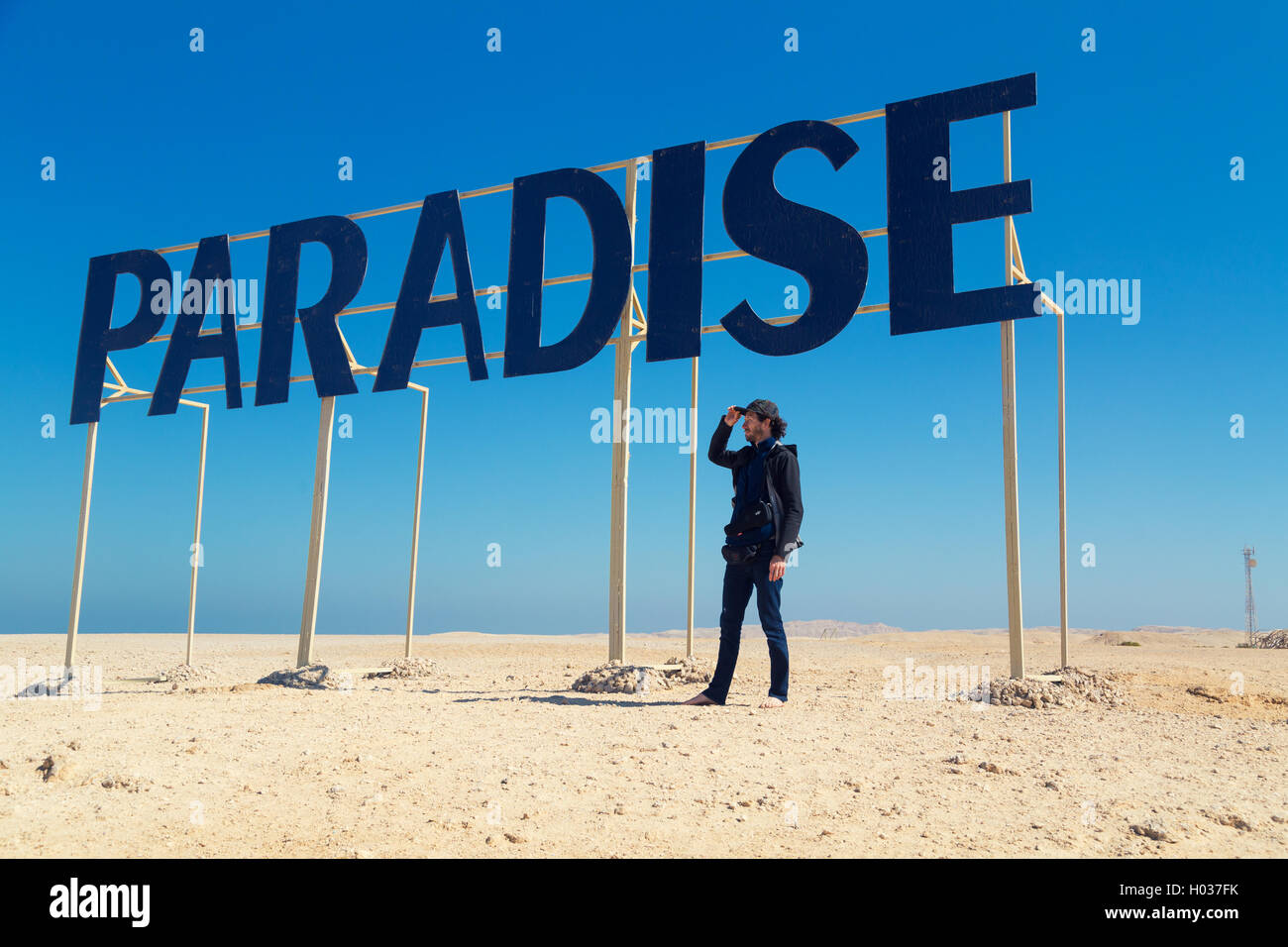 Tourist standing under the Paradise sign Stock Photo - Alamy