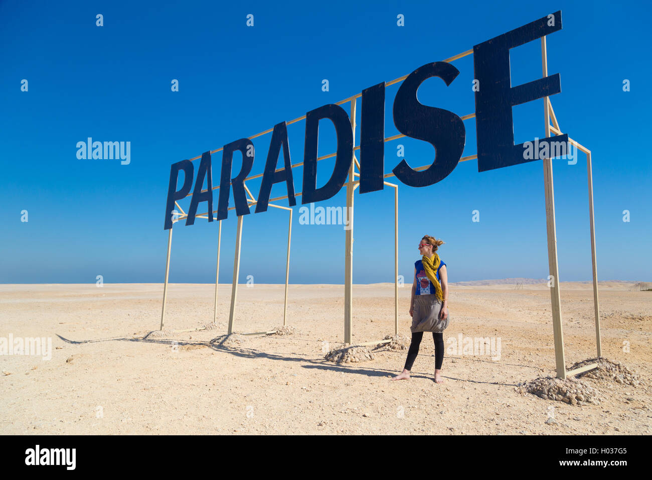 Tourist standing under the Paradise sign Stock Photo - Alamy