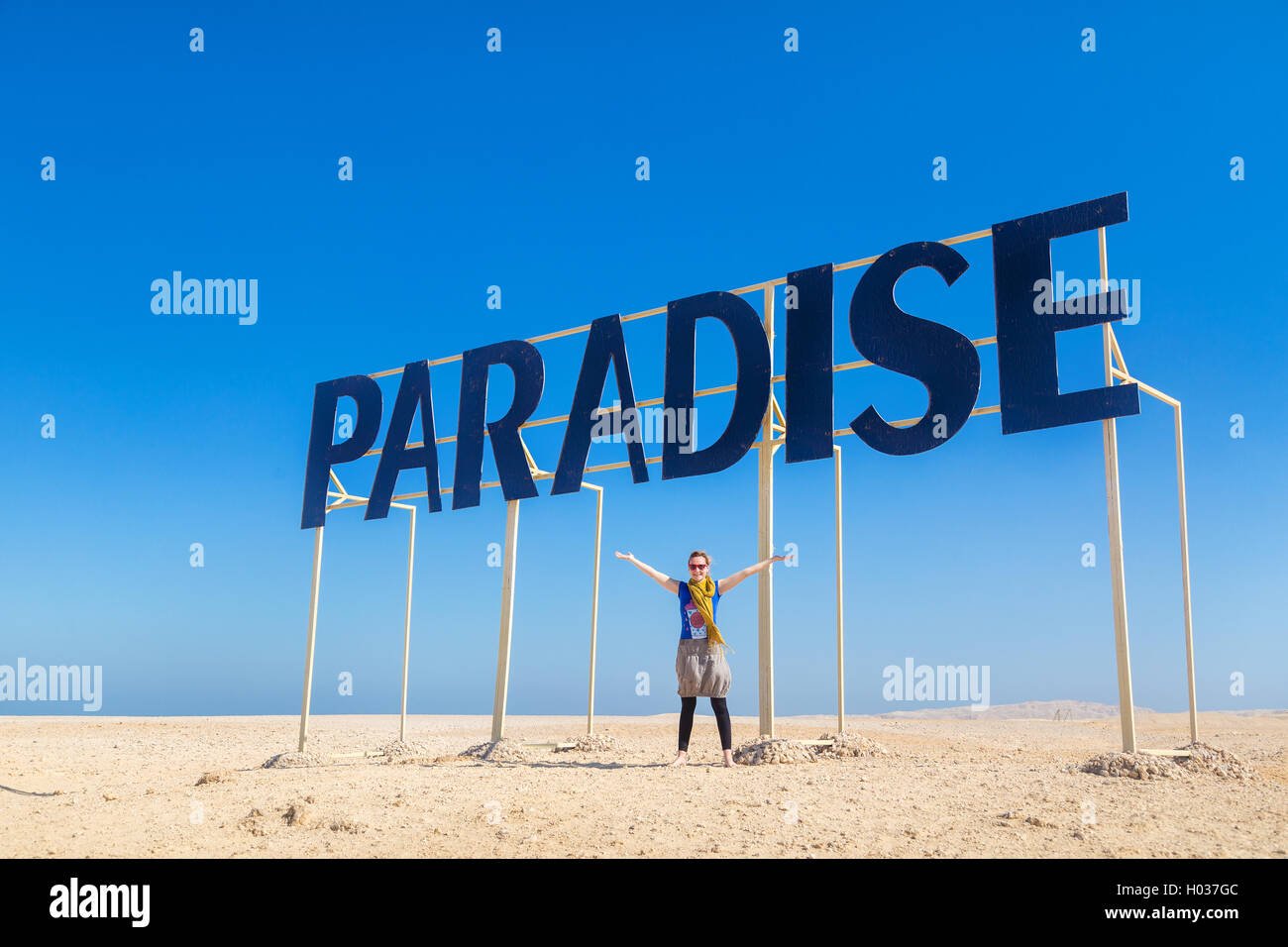Tourist spreading arms under the Paradise sign Stock Photo - Alamy