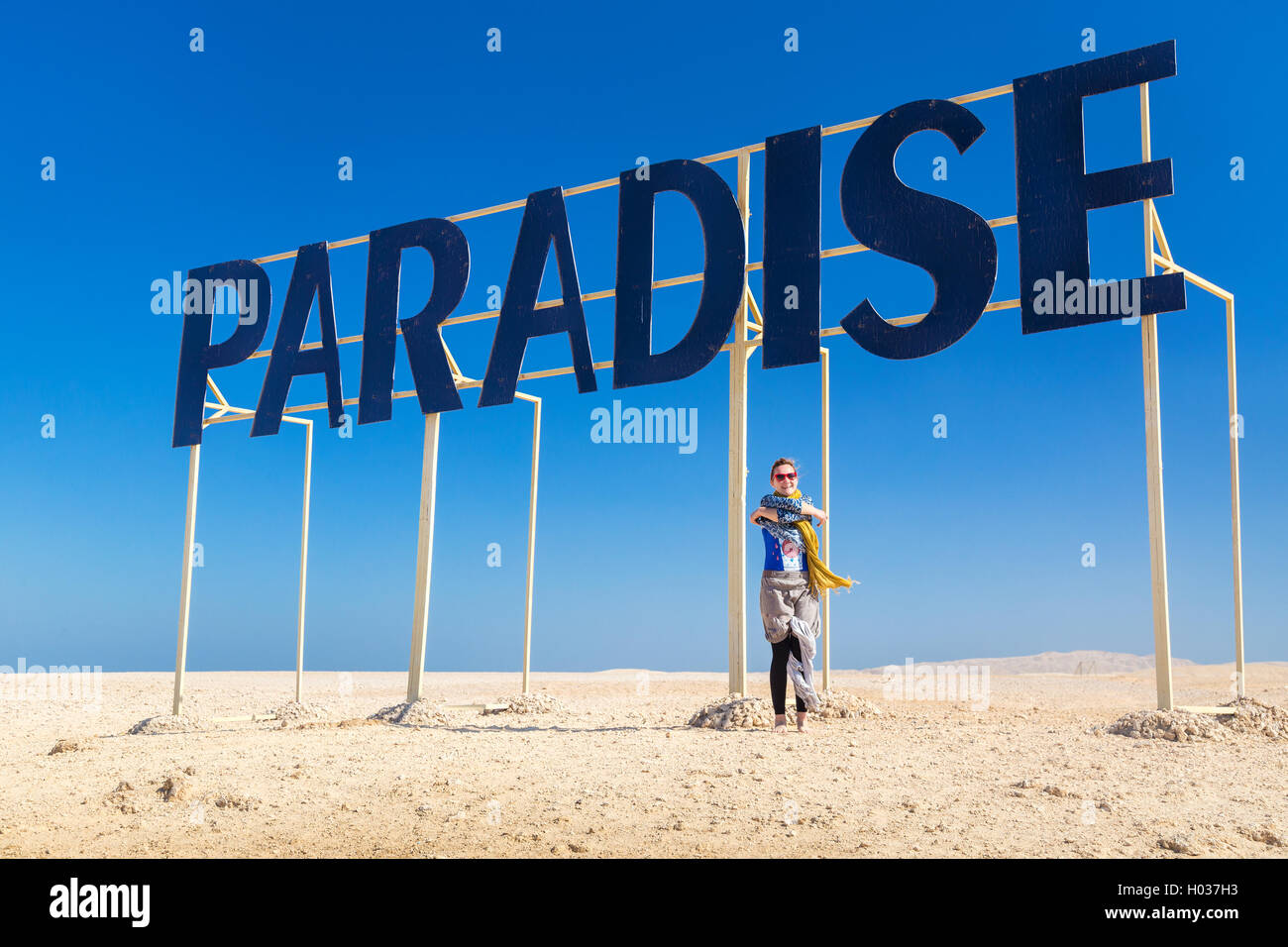 Tourist posing under the Paradise sign Stock Photo - Alamy