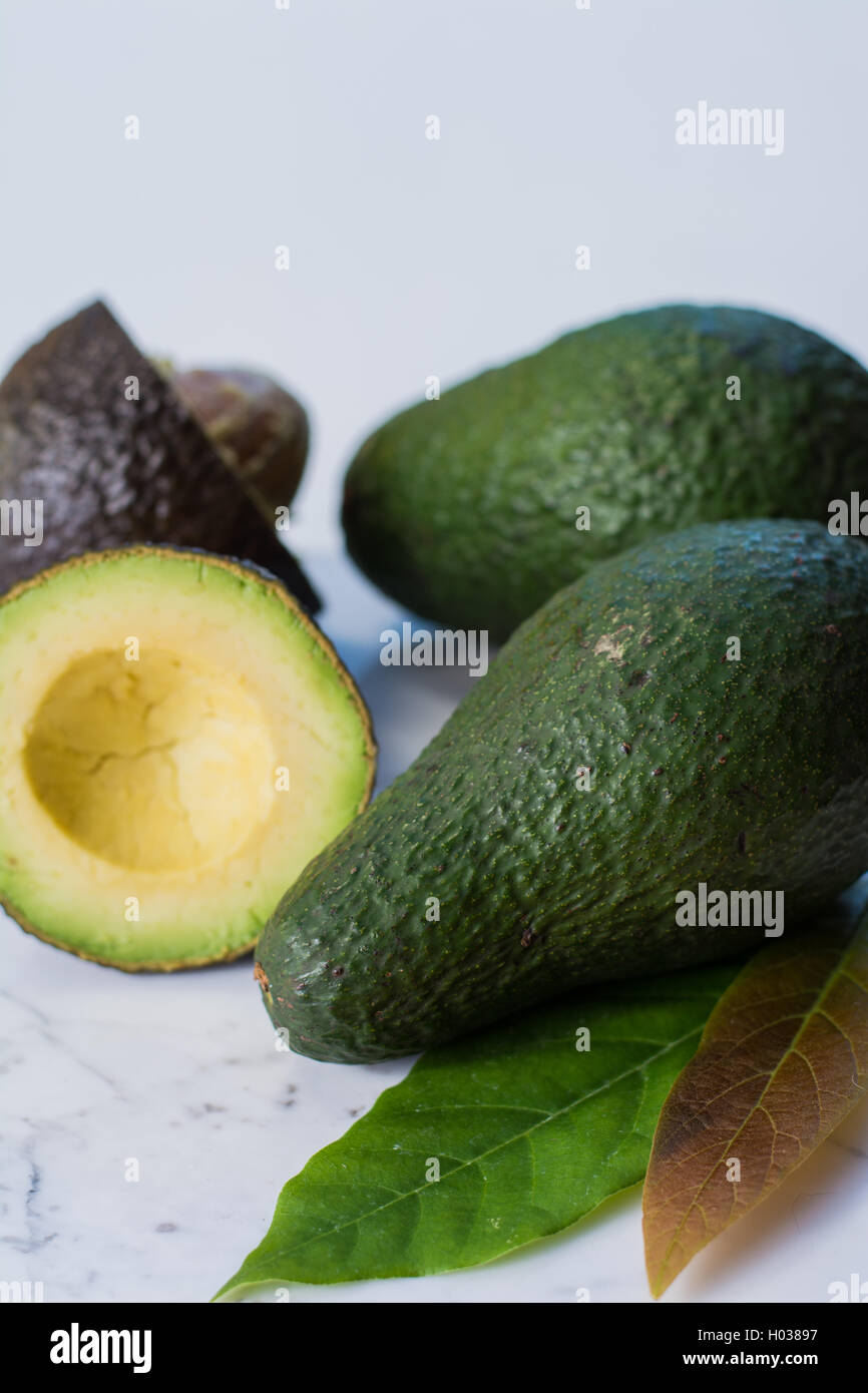 Green ripe avocado on white marble background Stock Photo - Alamy