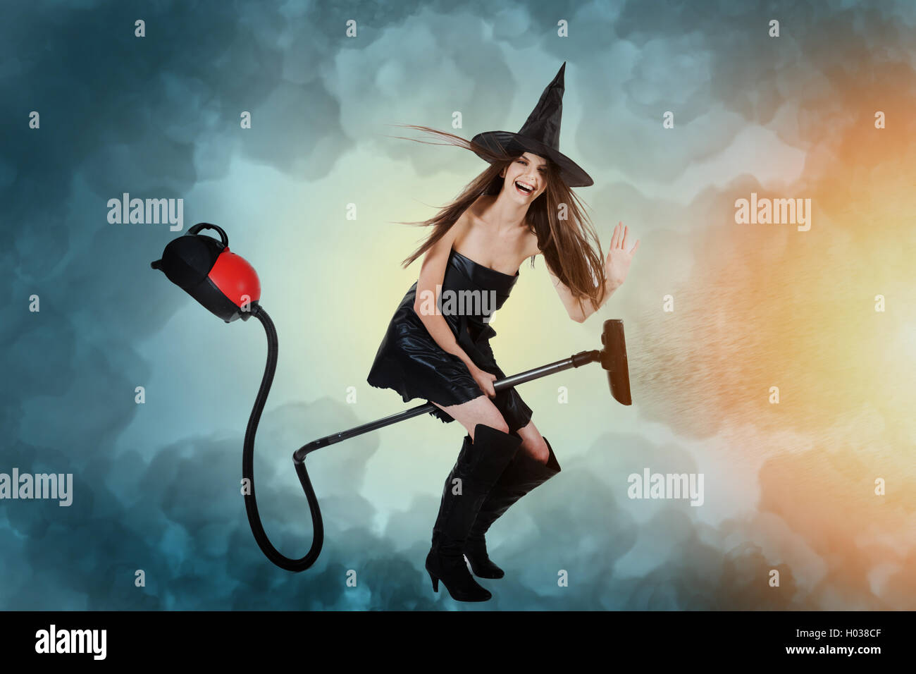 Young woman dressed as a witch riding a vacuum cleaner. Cleaning ...