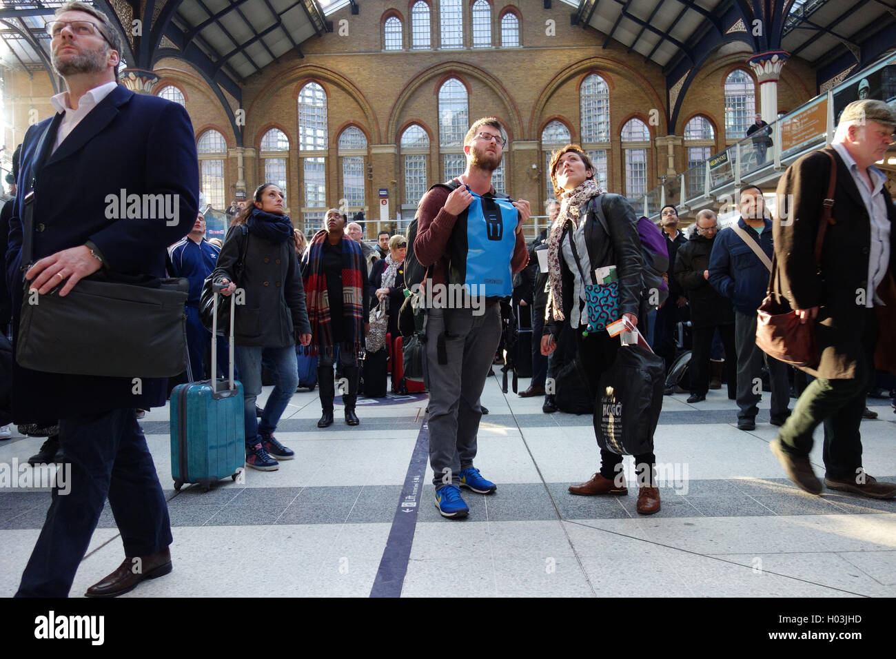 Commuters / passengers looking up at departure board, waiting for ...
