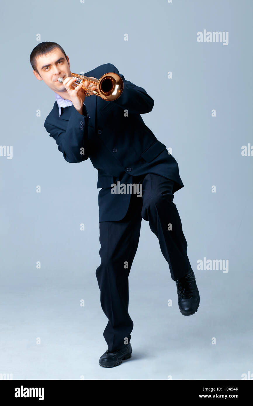 Adult man in suit playing on trumpet Stock Photo - Alamy
