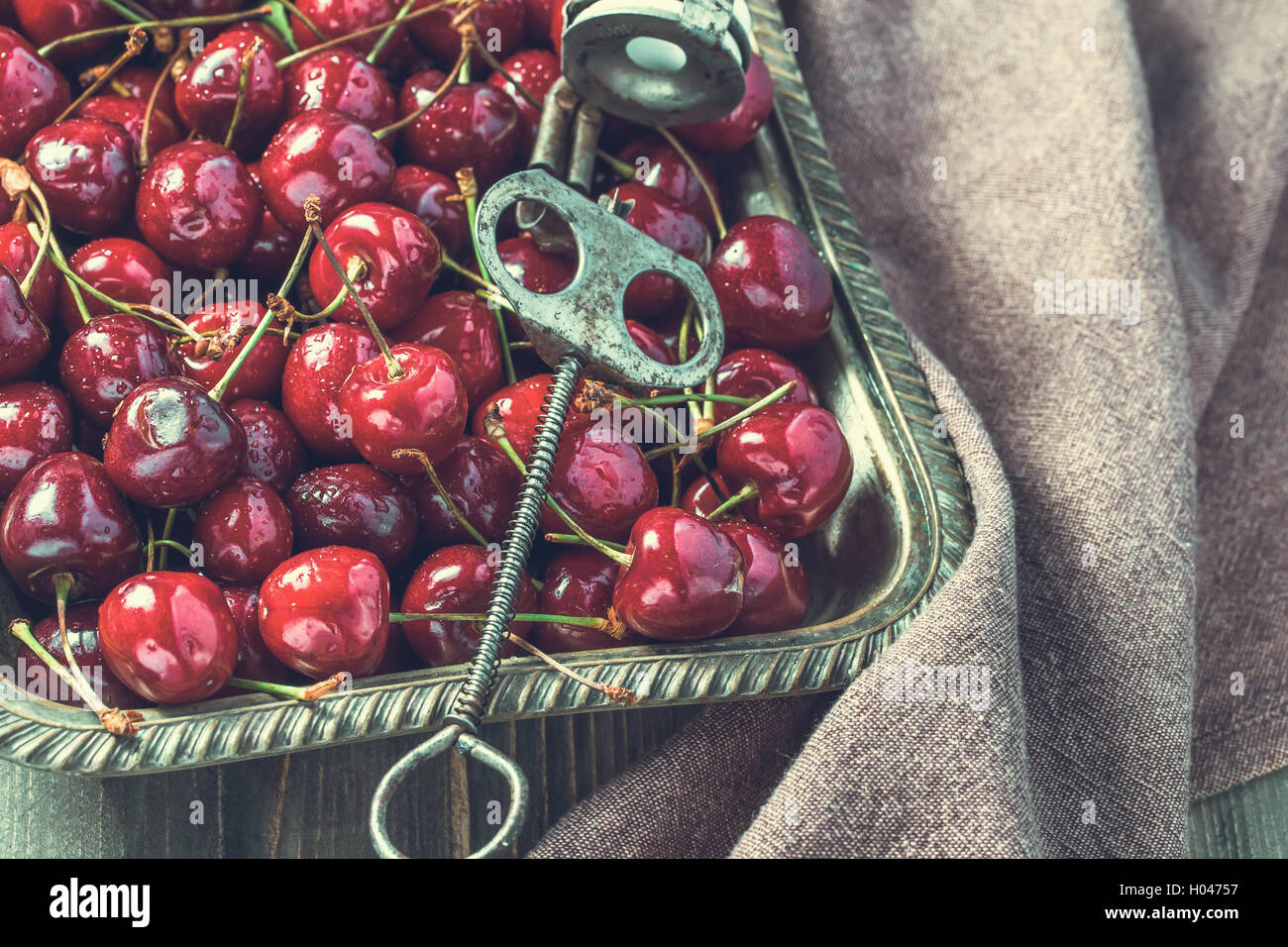 Vintage tray of cherries with stone remover Stock Photo - Alamy