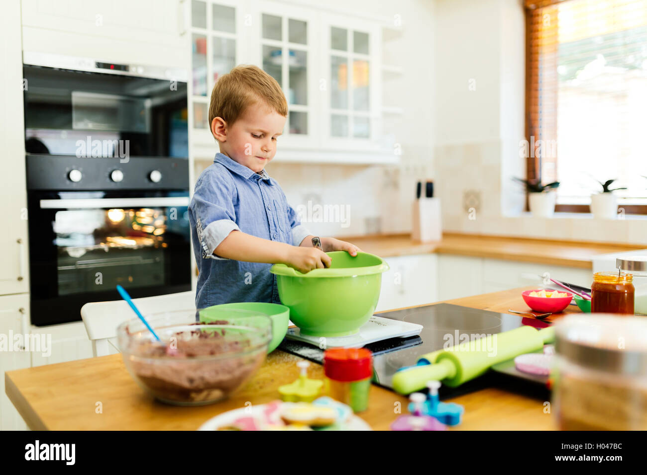 Child helping out in kitchen with the making of muffins Stock Photo - Alamy