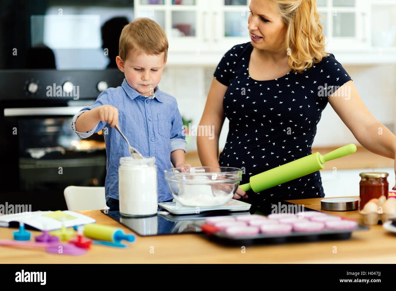 Beautiful child and mother baking in kitchen with love Stock Photo - Alamy