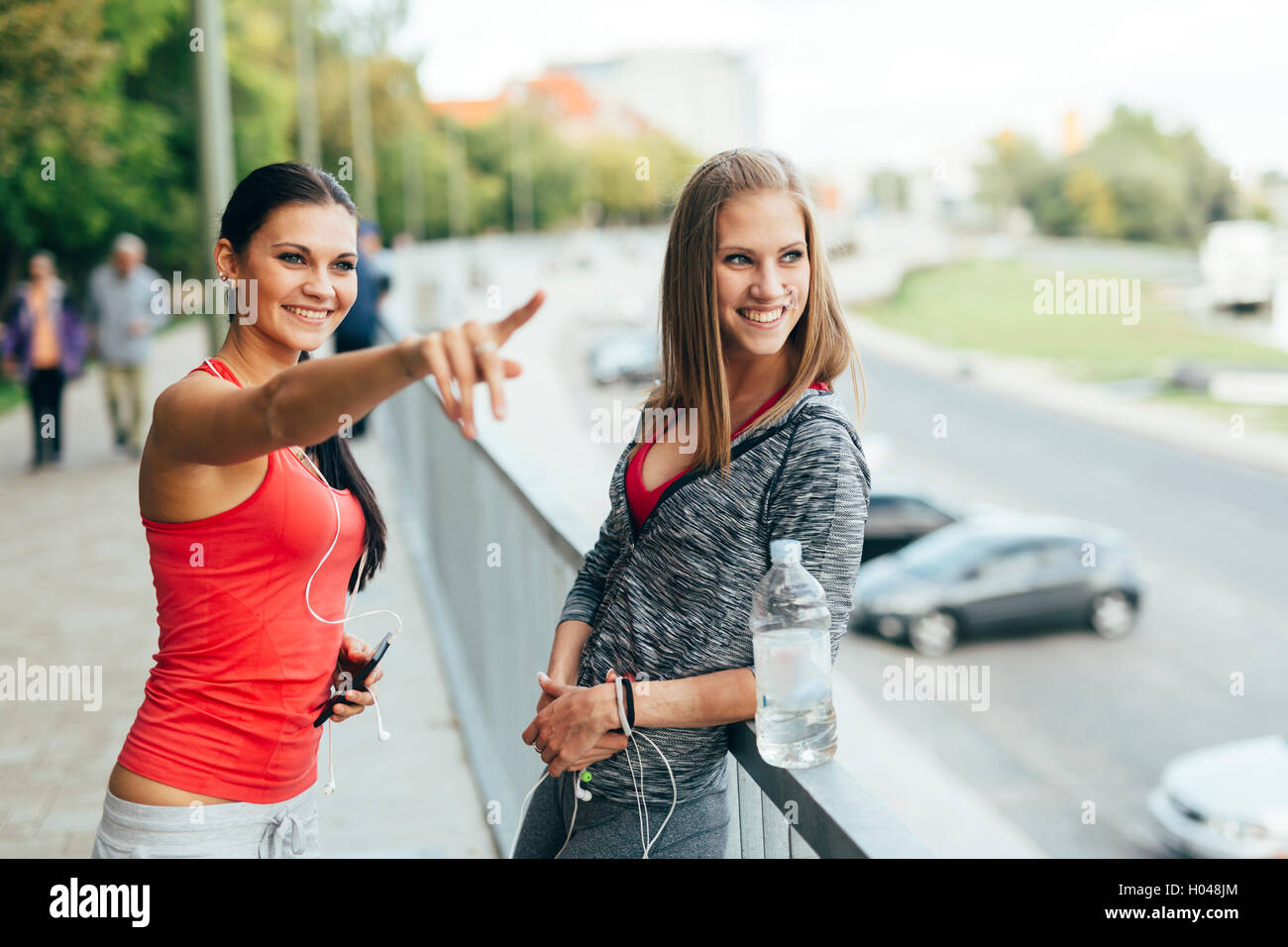 Fit women talking outdoors after jogging Stock Photo - Alamy