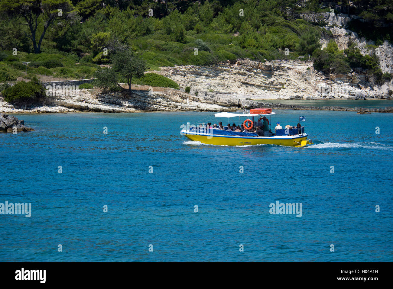 A small excursion boat full of tourists returning from Anti-Paxos and ...