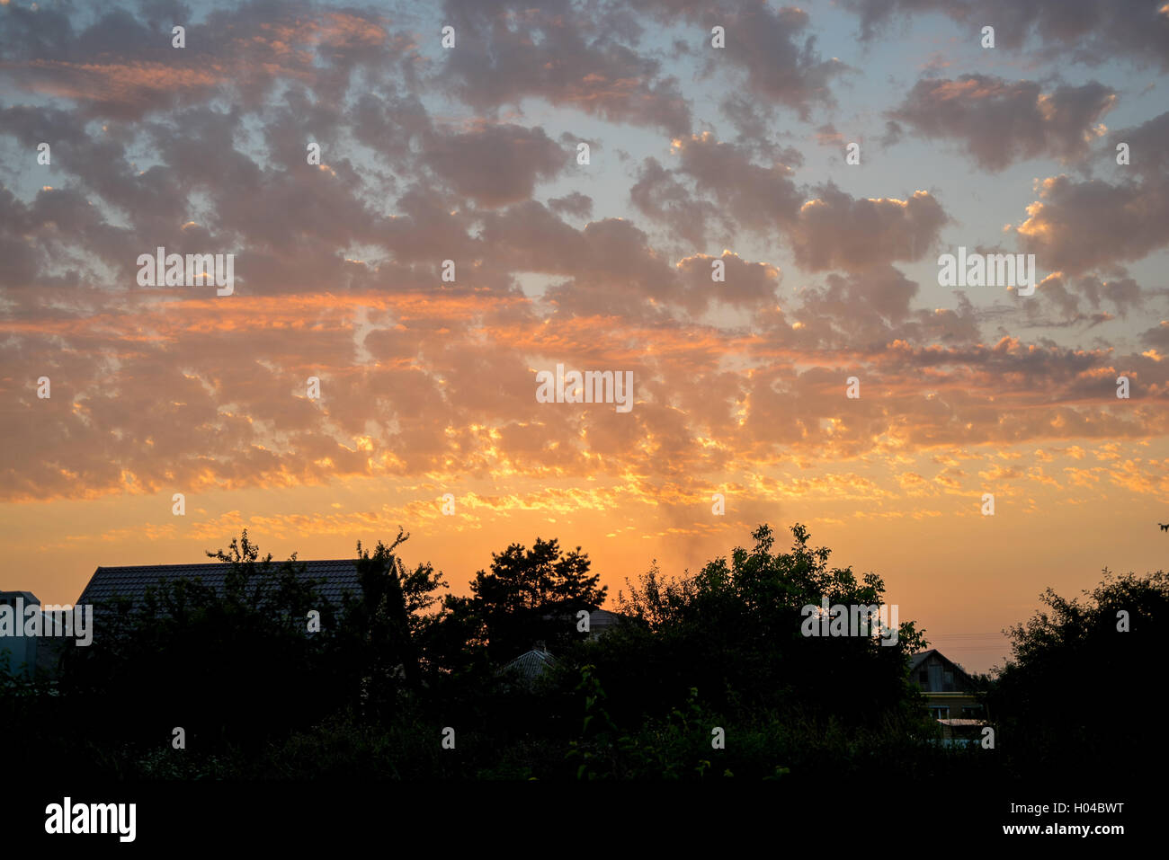 over the roofs of houses beautiful sunset . as if drawn by an artist's ...