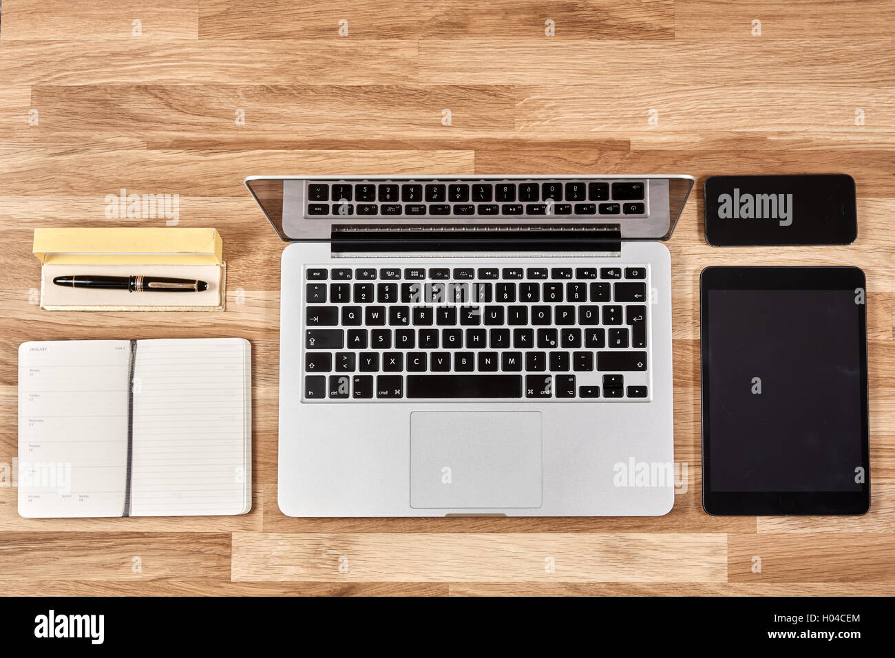 Notebook, laptop, tablet and mobil phone on glued and oiled oak table ...