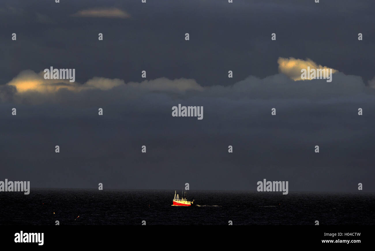 A small fishing boat heads out to sea along the northeast coast near ...