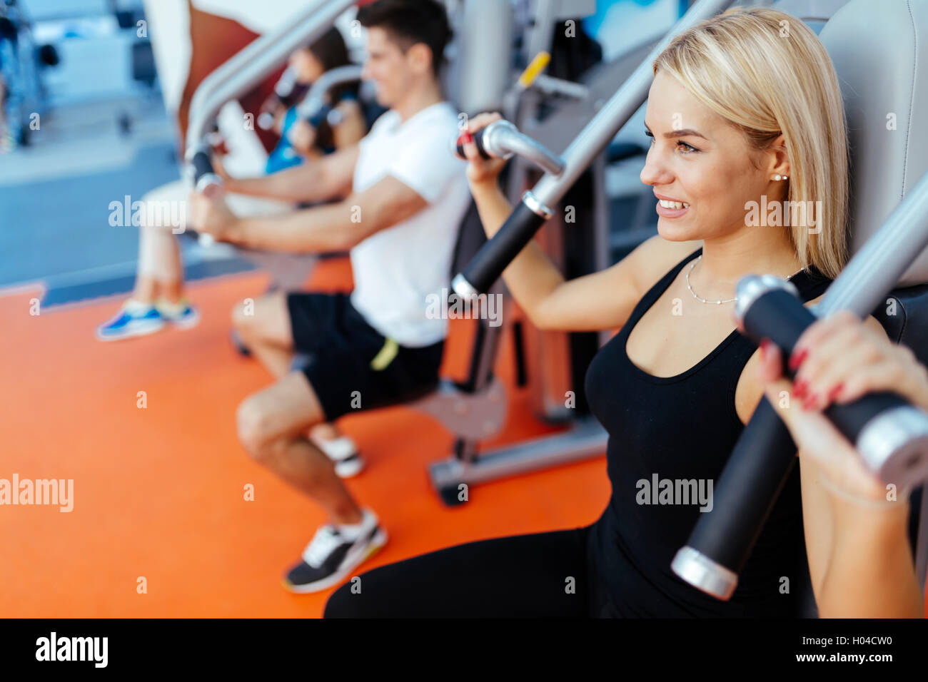 People exercising in gym on various machines Stock Photo - Alamy