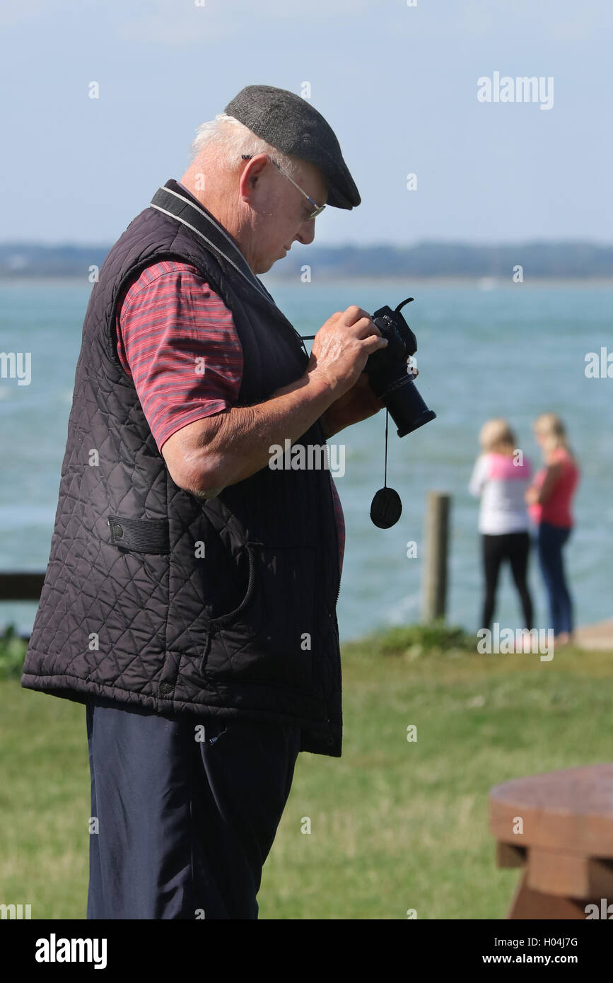 Chimping the images, mature man looking at the back of his digital ...