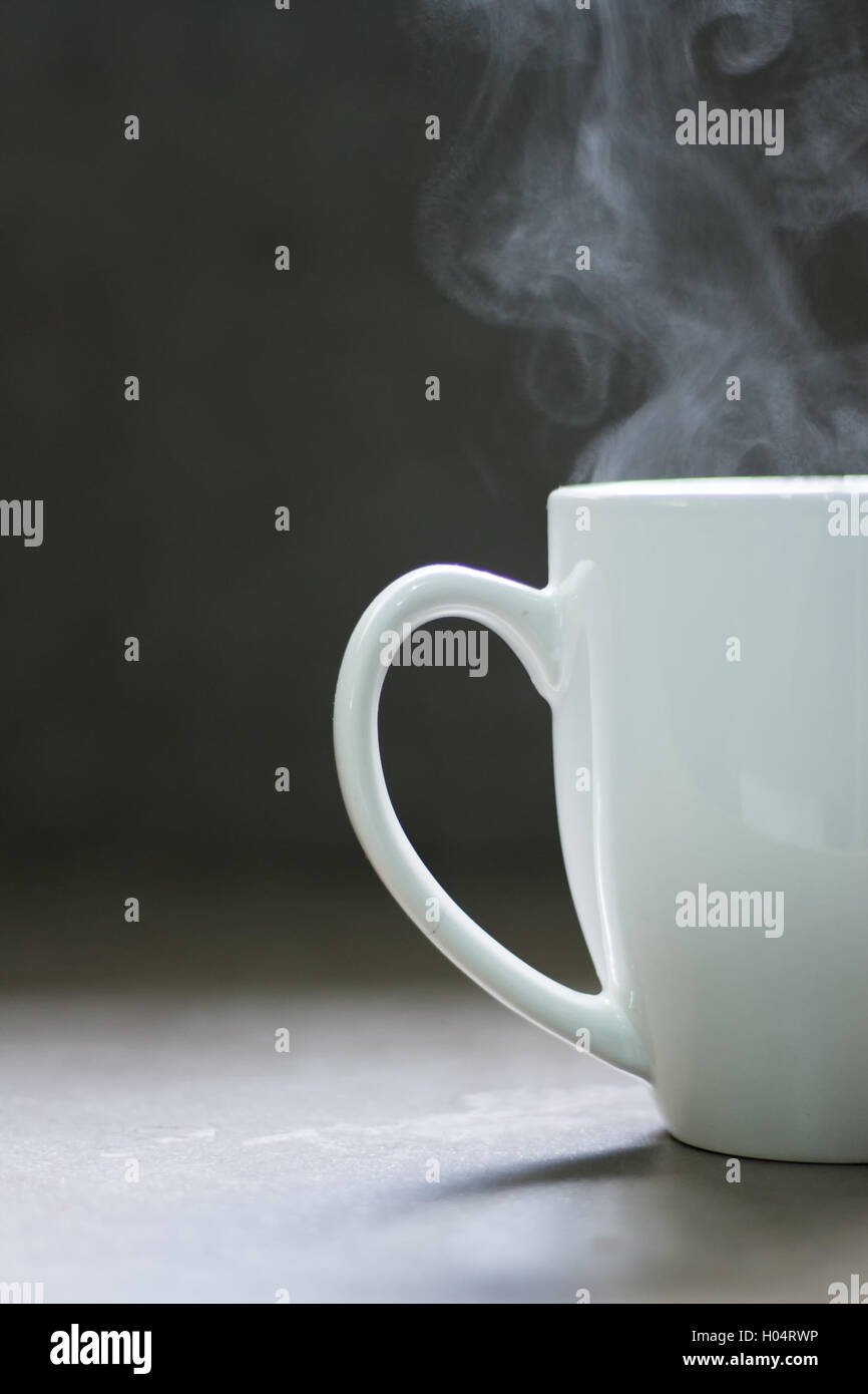 White ceramic mug with steaming liquid Stock Photo - Alamy