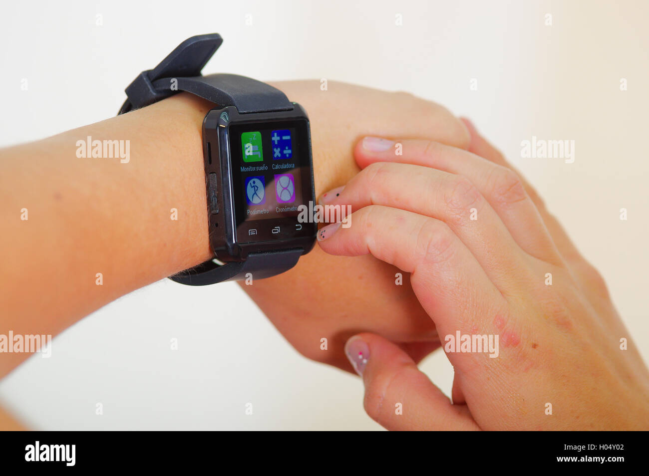 Closeup arm wrist wearing smart watch, screen lit up, using other hand ...