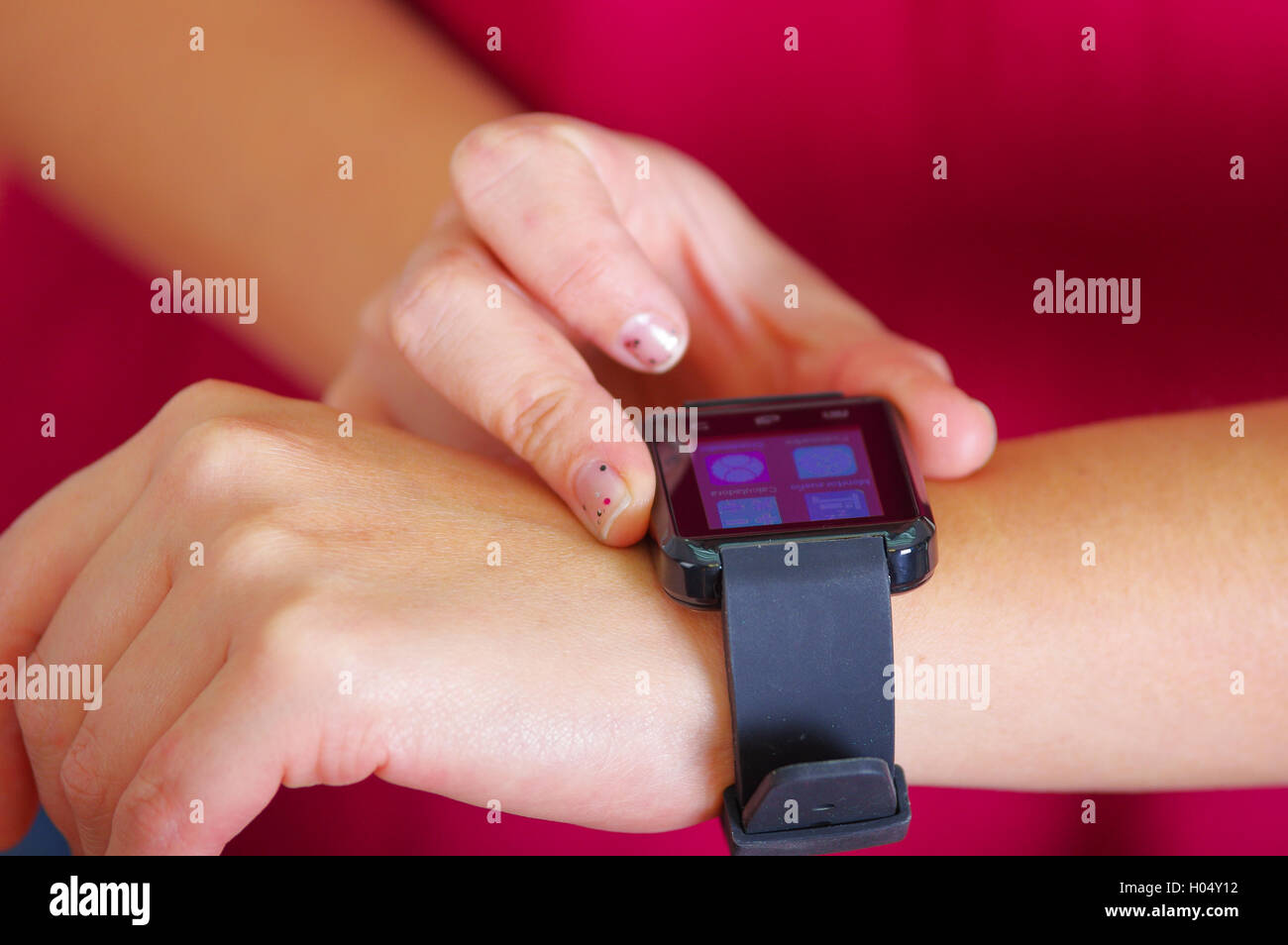 Closeup arm wrist wearing smart watch, screen lit up, using other hand ...