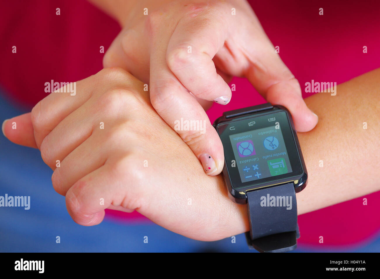 Closeup arm wrist wearing smart watch, screen lit up, using other hand ...