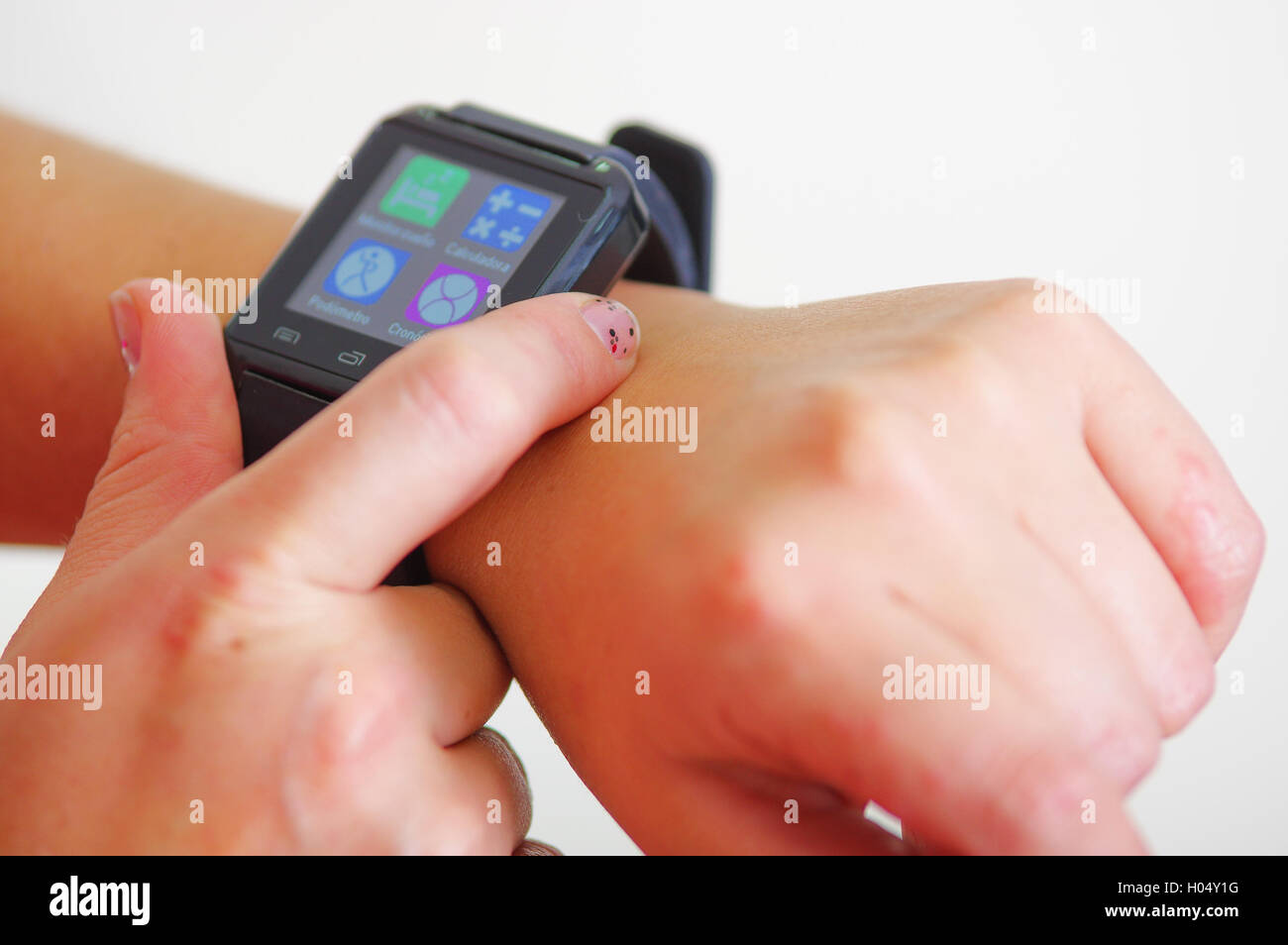 Closeup arm wrist wearing smart watch, screen lit up, using other hand ...