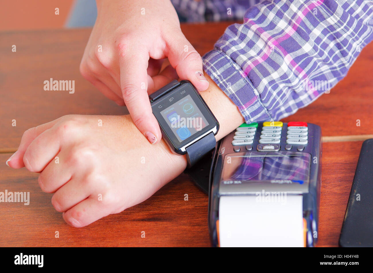 Closeup arm wrist wearing smart watch, screen lit up, using other hand ...