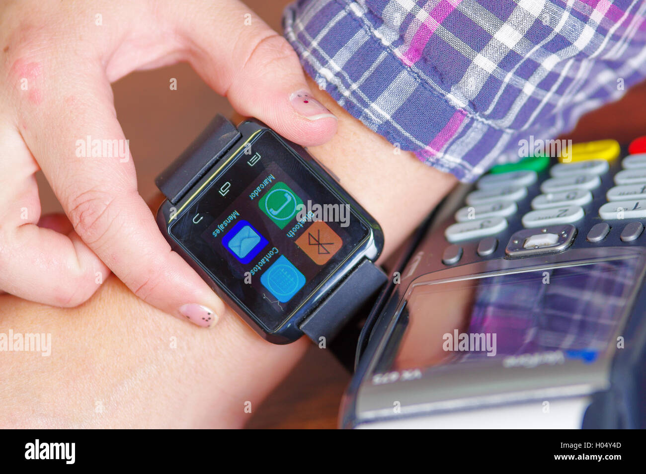 Closeup arm wrist wearing smart watch, screen lit up, using other hand ...
