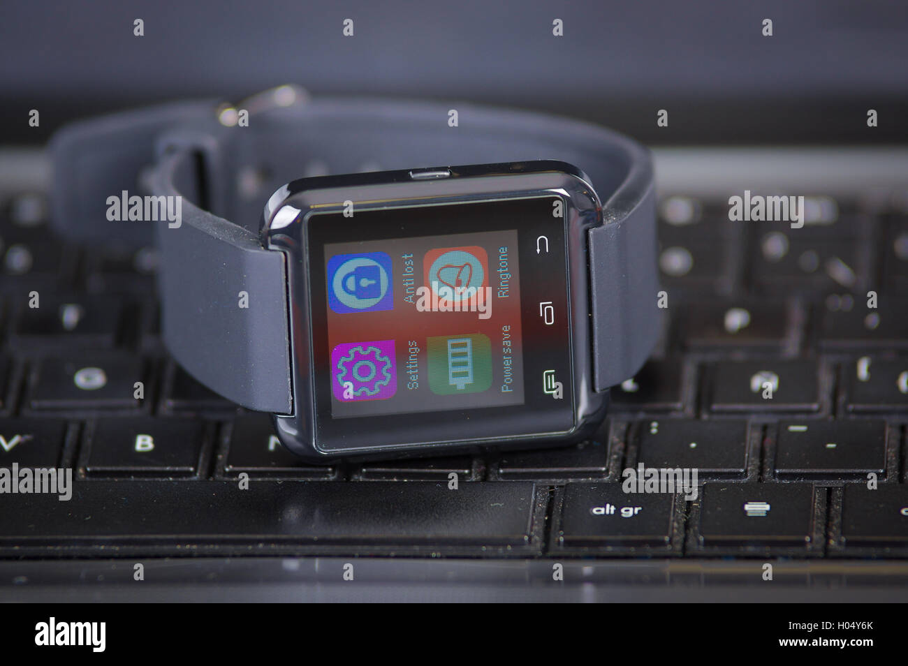 Smartwatch with screen lit up sitting on top of computer keyboard, very ...