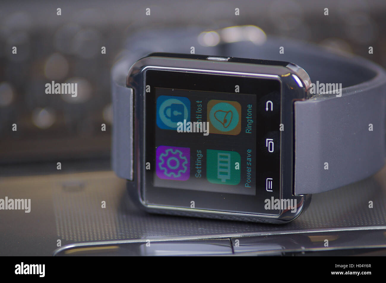 Smartwatch with screen lit up sitting on top of computer keyboard, very ...