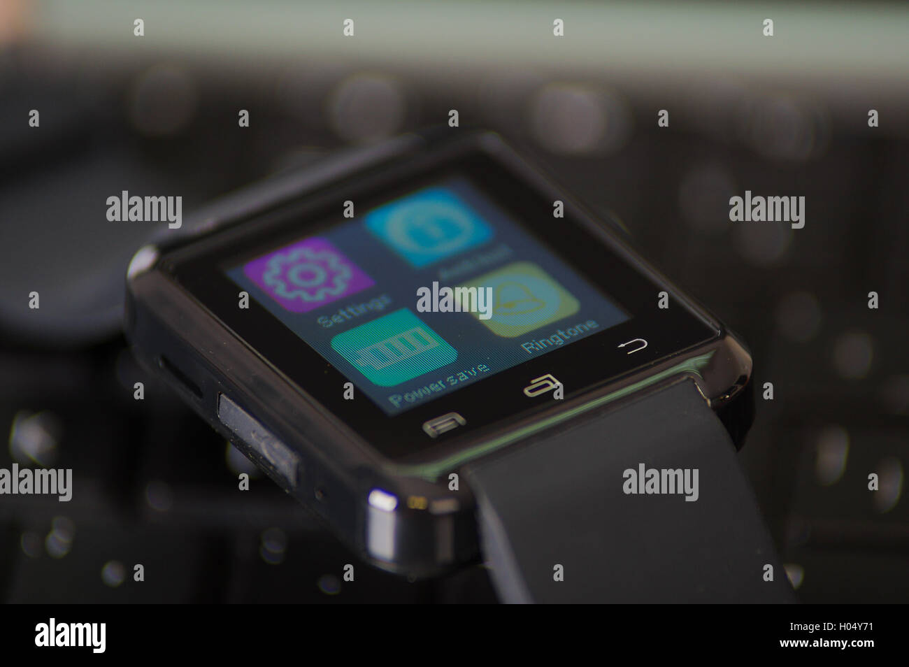 Smartwatch with screen lit up sitting on top of computer keyboard, very ...