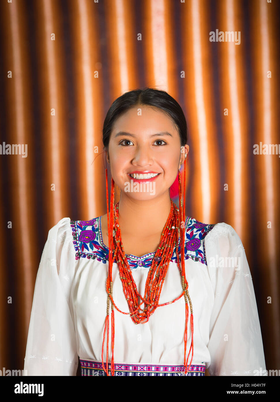 Beautiful hispanic model wearing andean traditional clothing smiling and posing for camera ...
