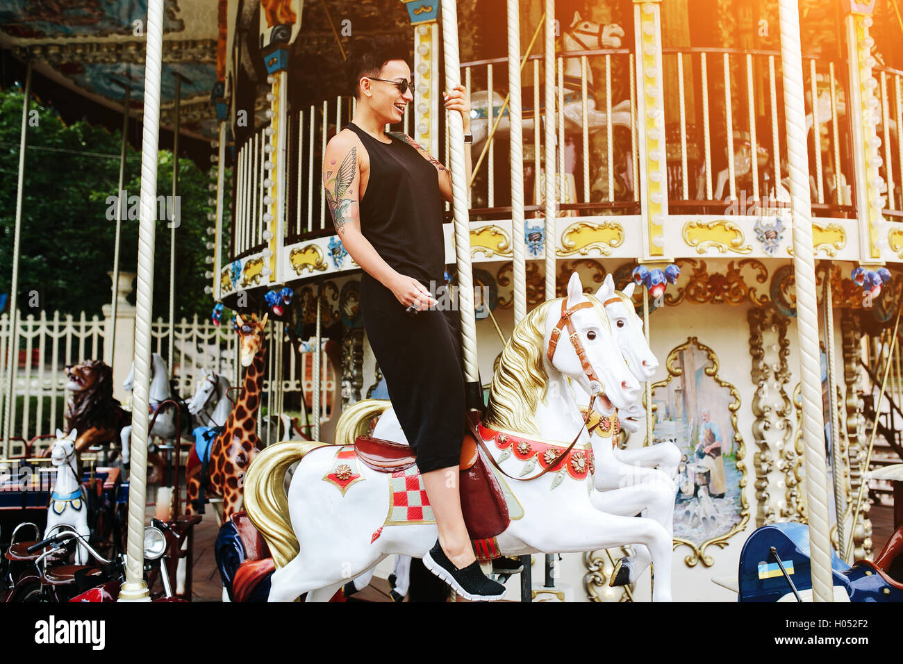 woman sitting at horse on a carousel Stock Photo - Alamy