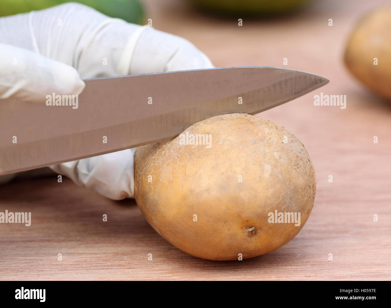 Cutting potato with a kitchen knife Stock Photo - Alamy