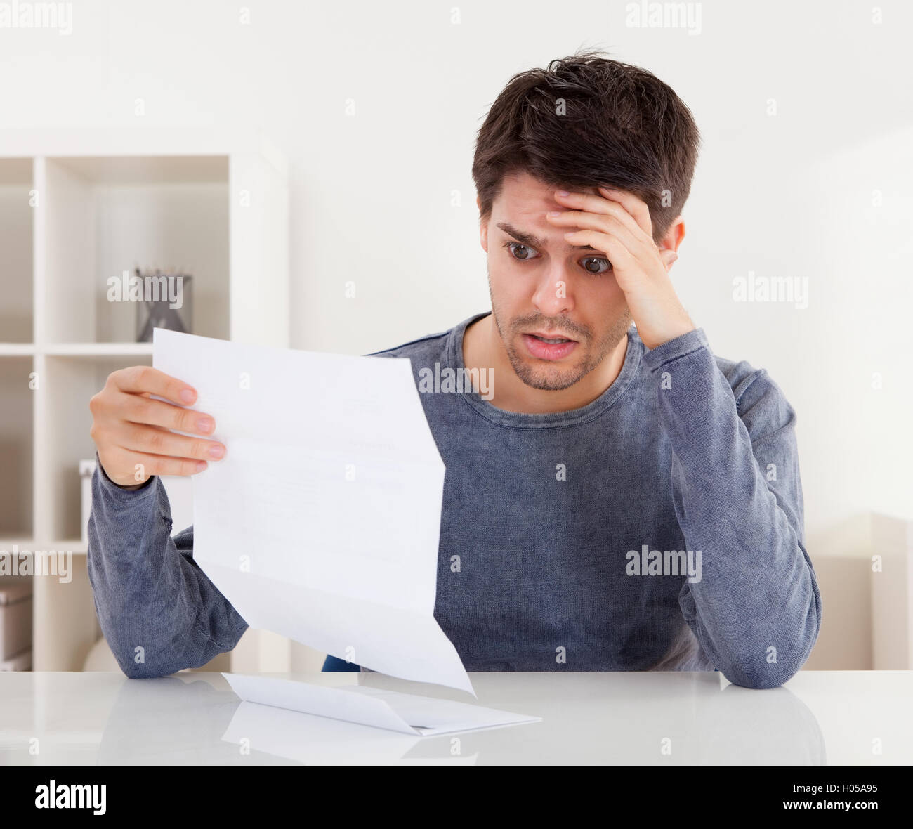Horrified man reading a document Stock Photo - Alamy
