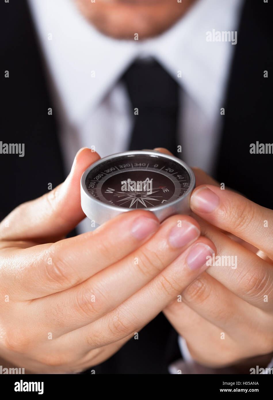 Businessman looking at a compass Stock Photo - Alamy