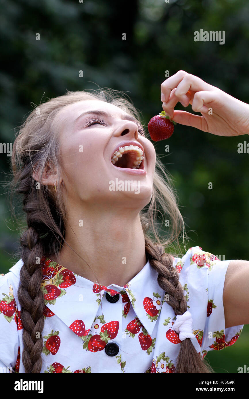 Beautiful girl with a strawberry Stock Photo - Alamy