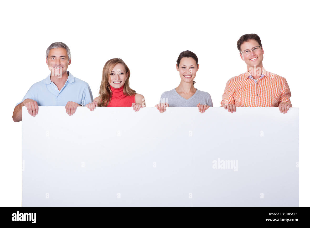 Two happy couples holding up a blank banner Stock Photo - Alamy
