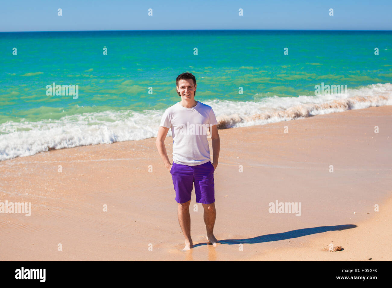 Young man on tropical beach vacation Stock Photo - Alamy