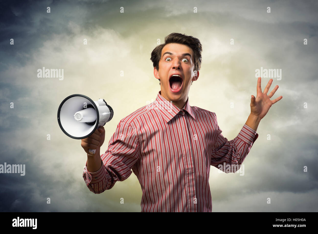 Portrait of a young man shouting using megaphone Stock Photo - Alamy