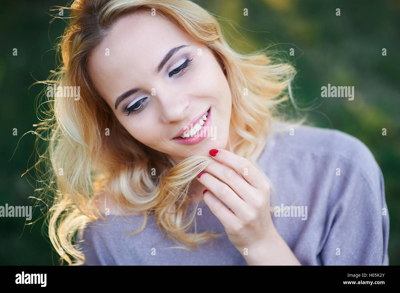 Portrait of a beautiful woman smiling outdoors in park Stock Photo - Alamy