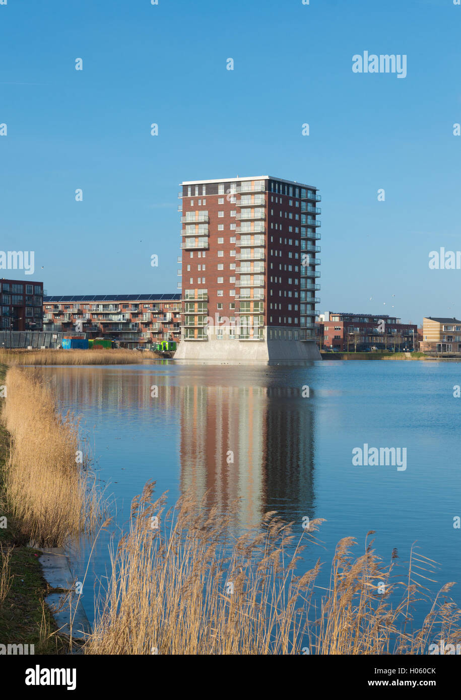 modern apartment building reflected in a lake Stock Photo - Alamy