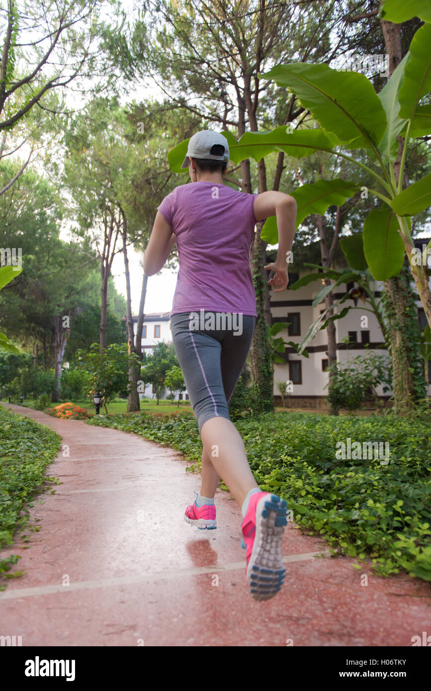 sporty woman jogging on sidewalk at early morning Stock Photo - Alamy