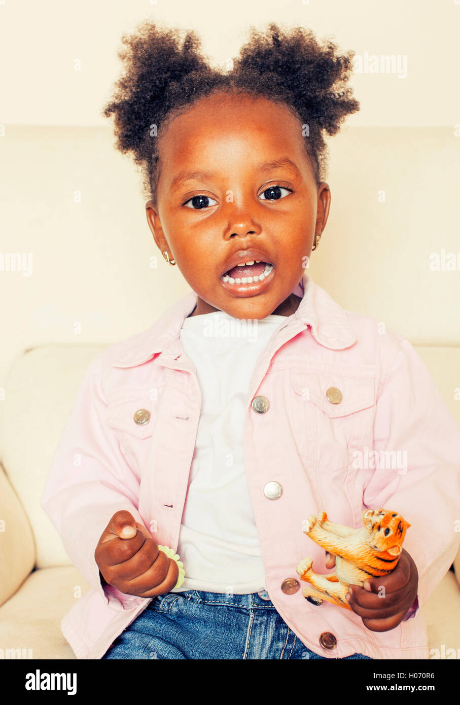 little cute sweet african-american girl playing happy with toys at home ...