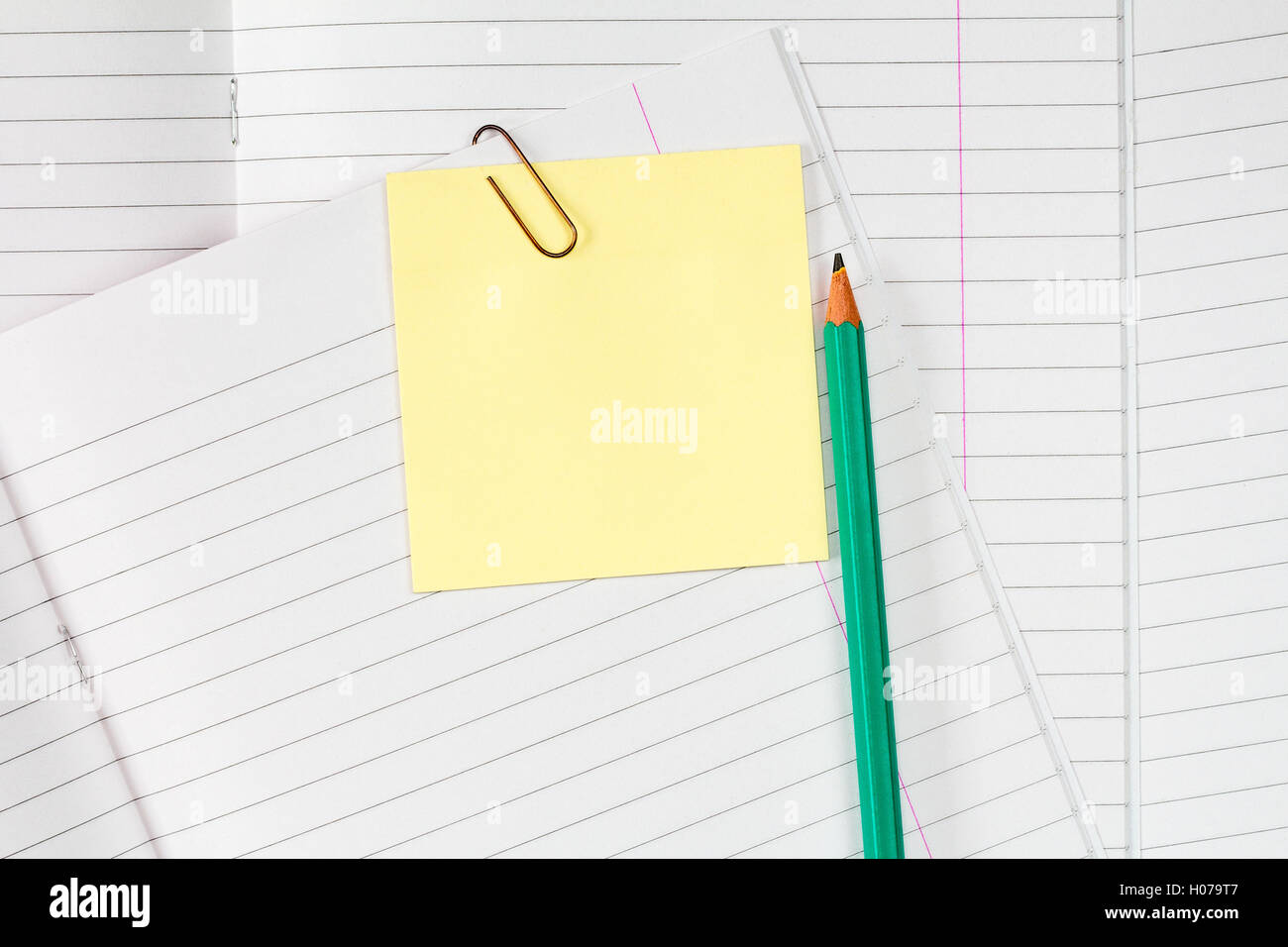 Lined exercise-book with blank sticky note and pencil Stock Photo - Alamy