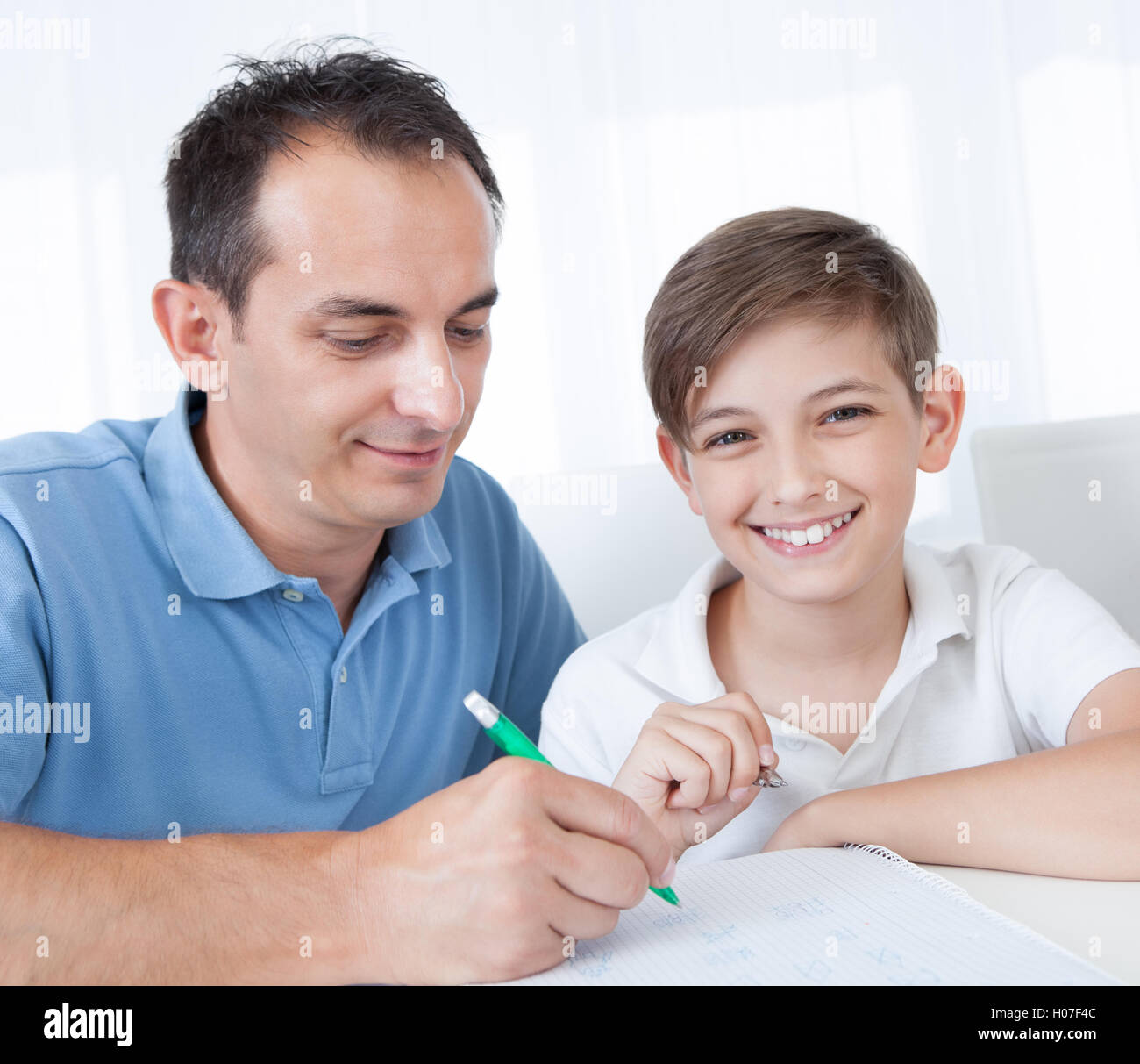 Portrait Of Father And Son Doing Homework Stock Photo - Alamy